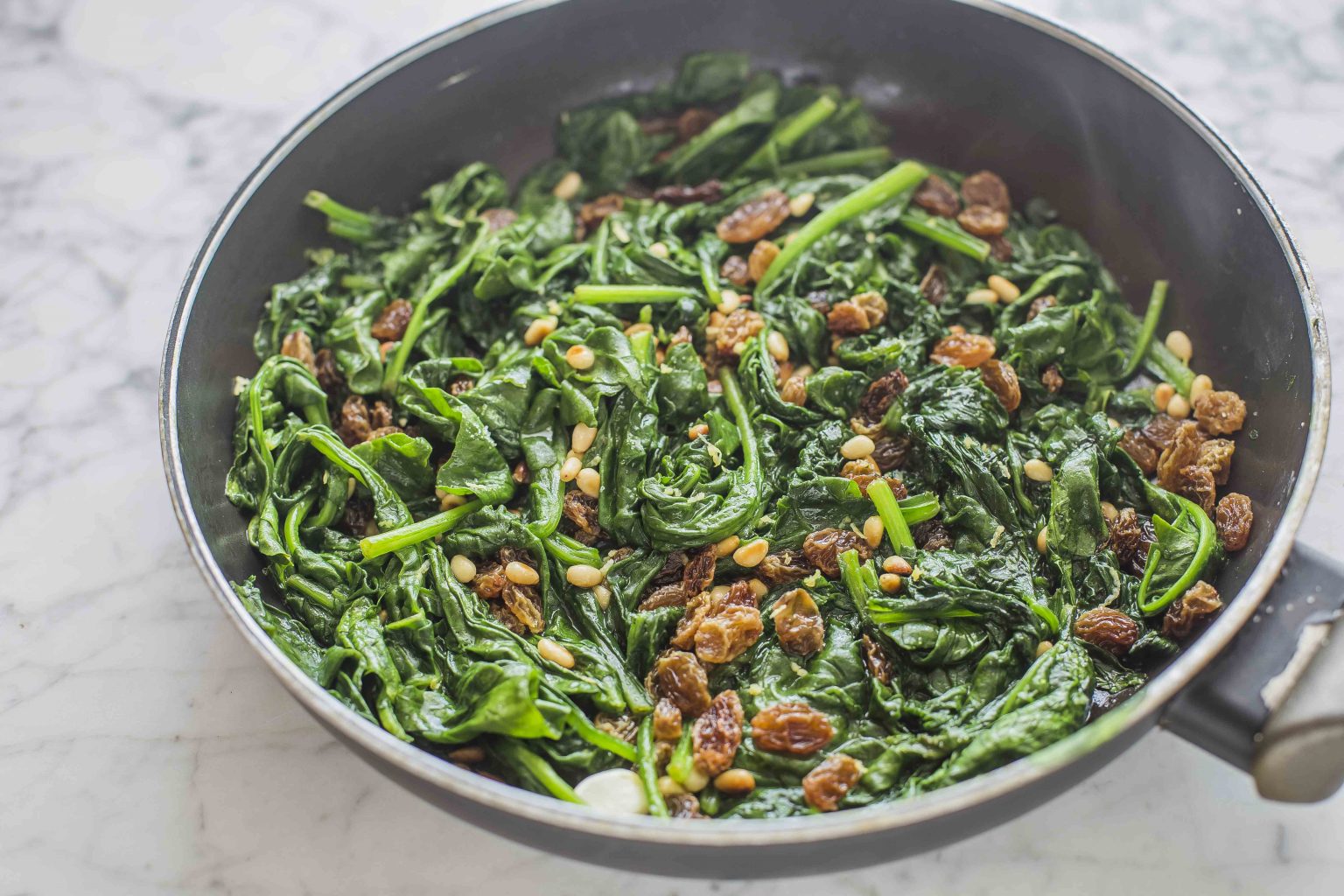 Ricetta Spinaci in padella con uvetta e pinoli | Agrodolce